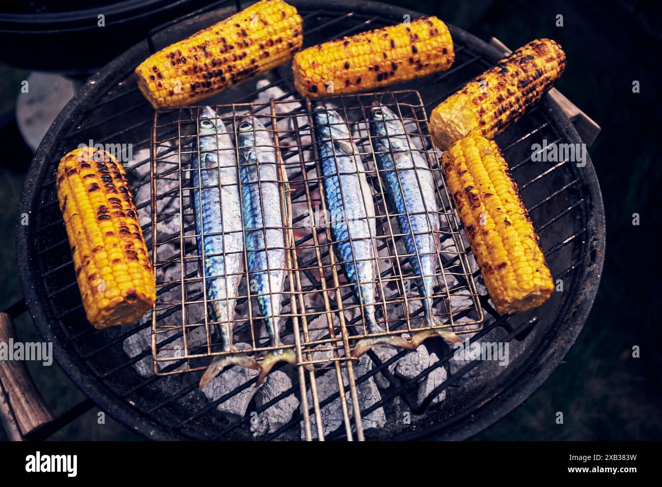 Fishes with corns on barbecue grill Stock Photo - Alamy