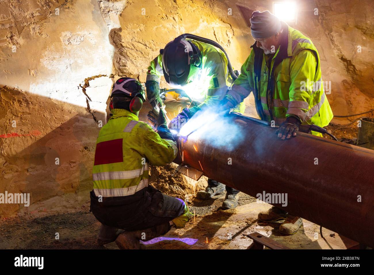 Male workers uses machinery while cutting pipe in construction industry ...