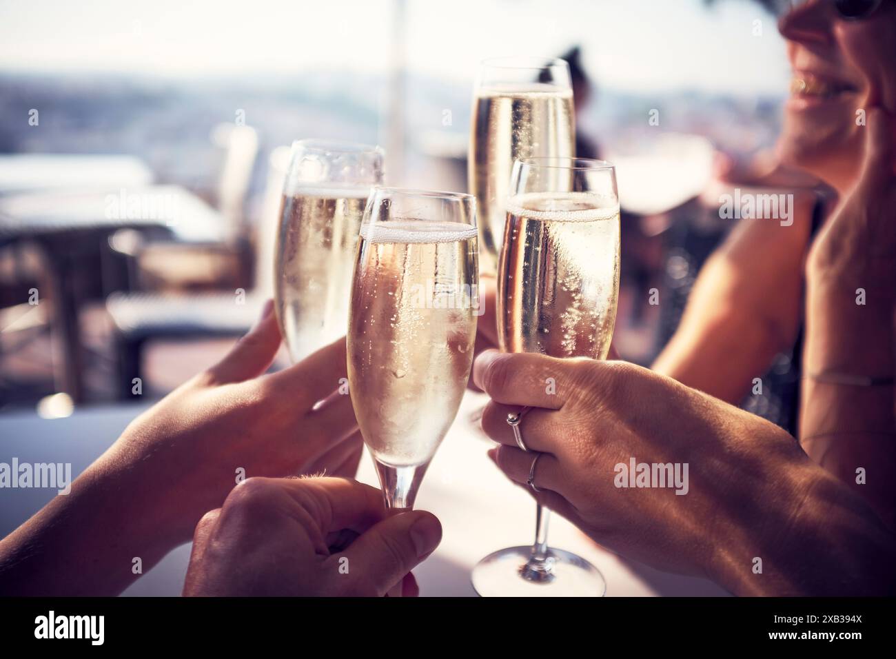 Hands of male and female friends toasting champagne flutes in ...