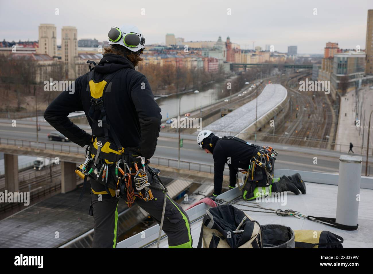 Male rope access workers with equipment working on rooftop Stock Photo ...
