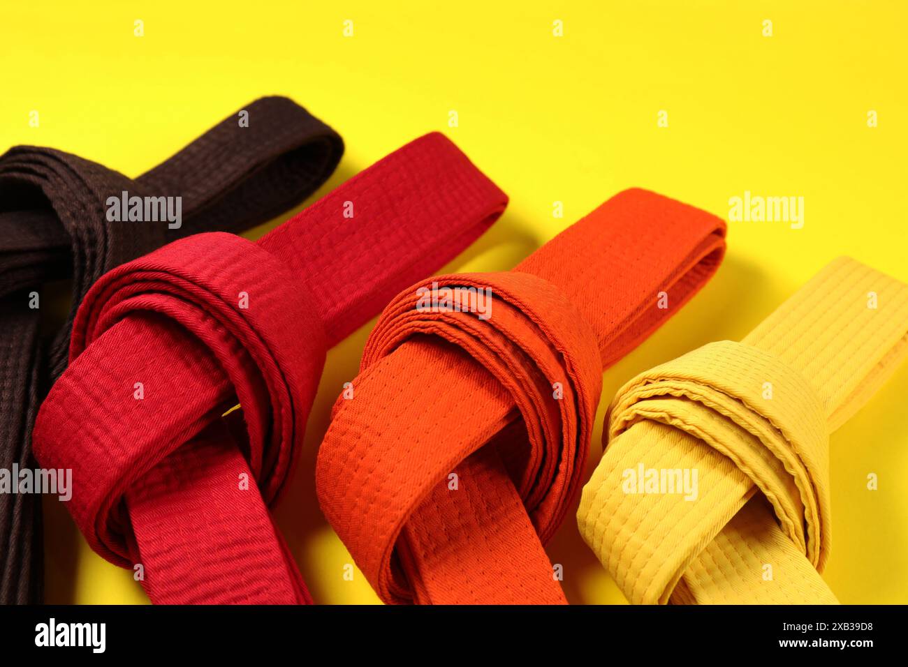Colorful karate belts on yellow background, closeup Stock Photo - Alamy