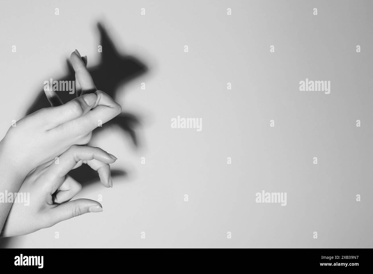 Shadow puppet. Woman making hand gesture like rabbit on light ...