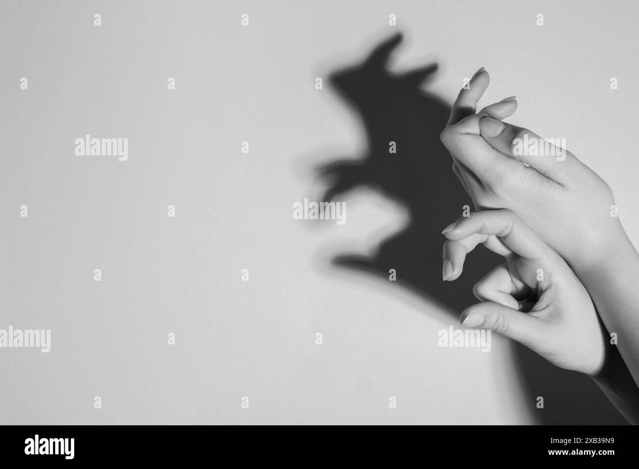 Shadow puppet. Woman making hand gesture like rabbit on light ...