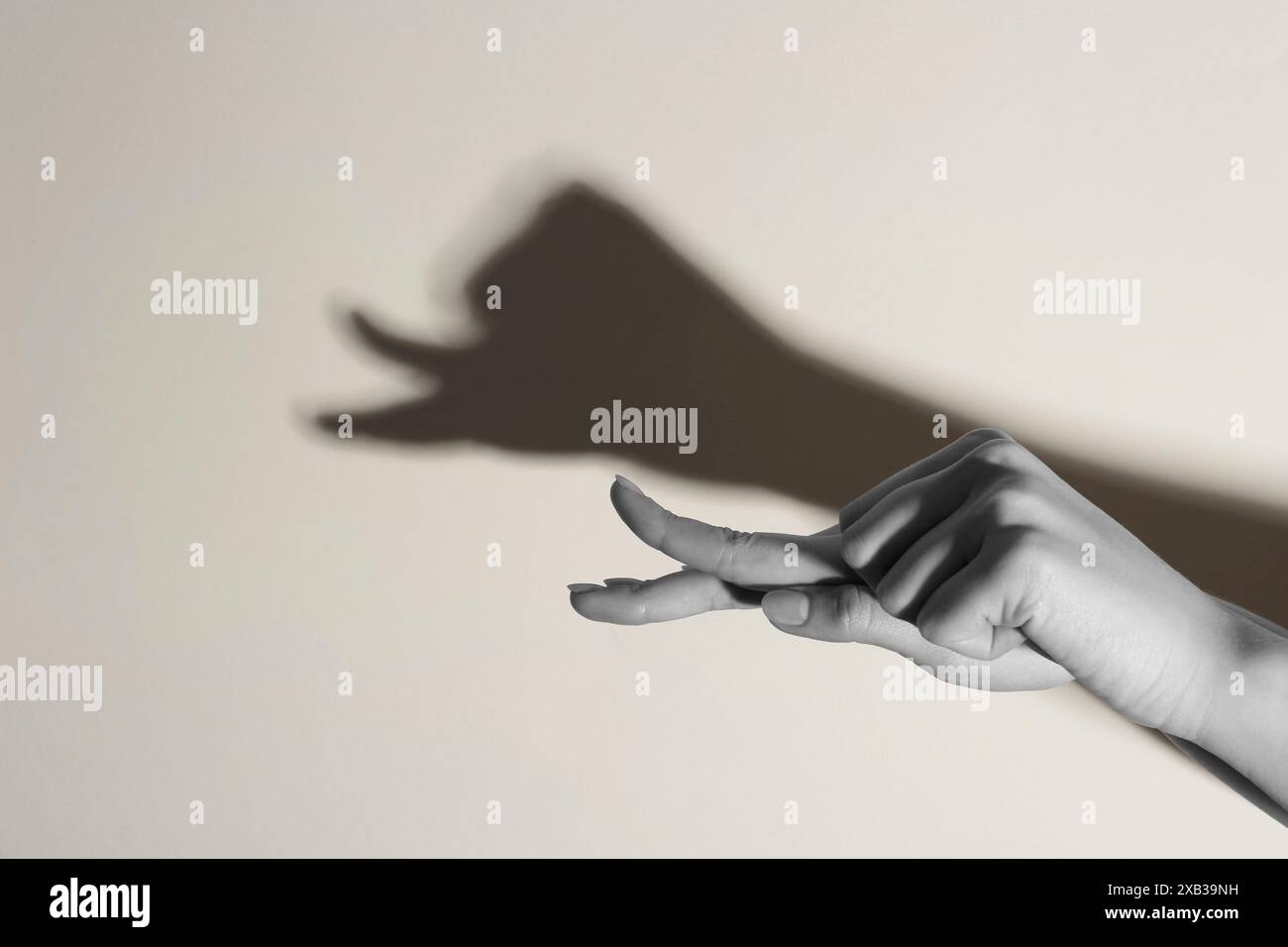 Shadow puppet. Woman making hand gesture like snail on light background ...