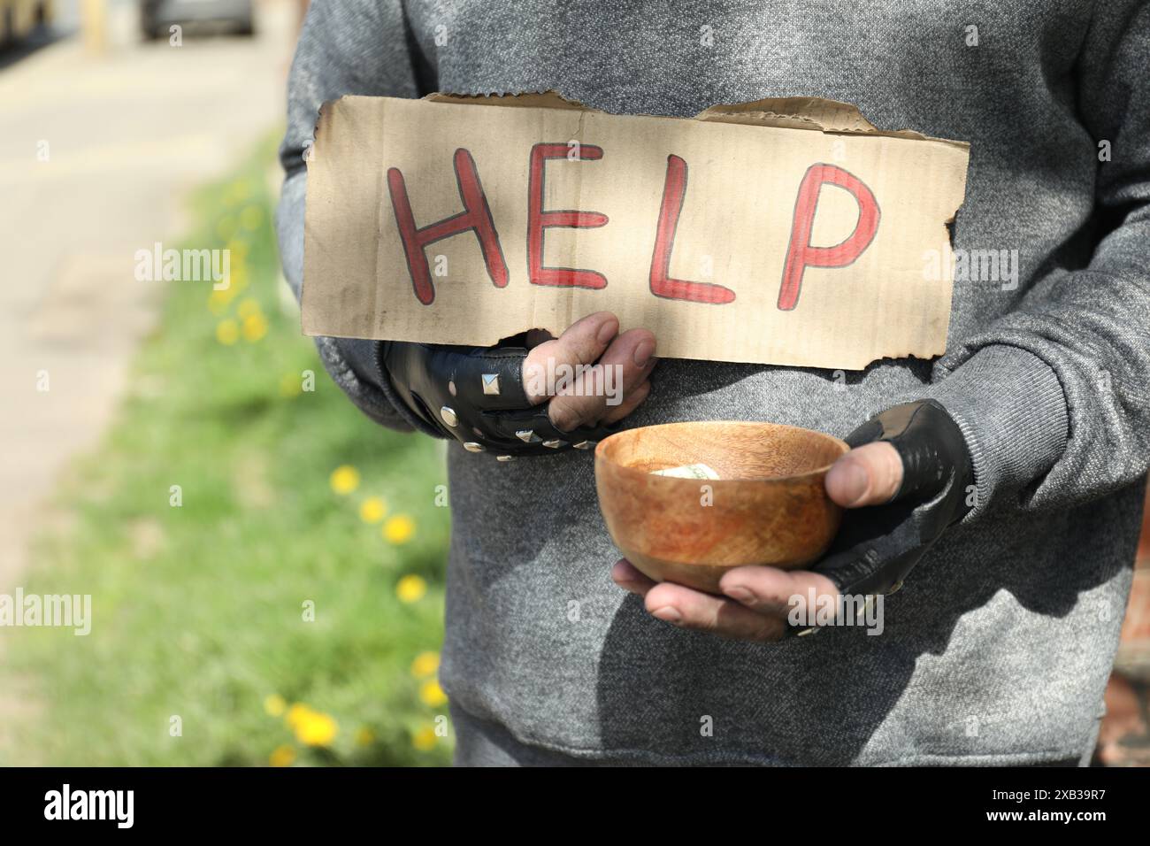Poor homeless man holding help sign and bowl with donations outdoors ...