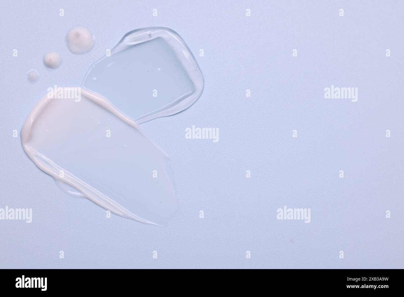 Samples of face cream on light blue background, top view. Space for ...