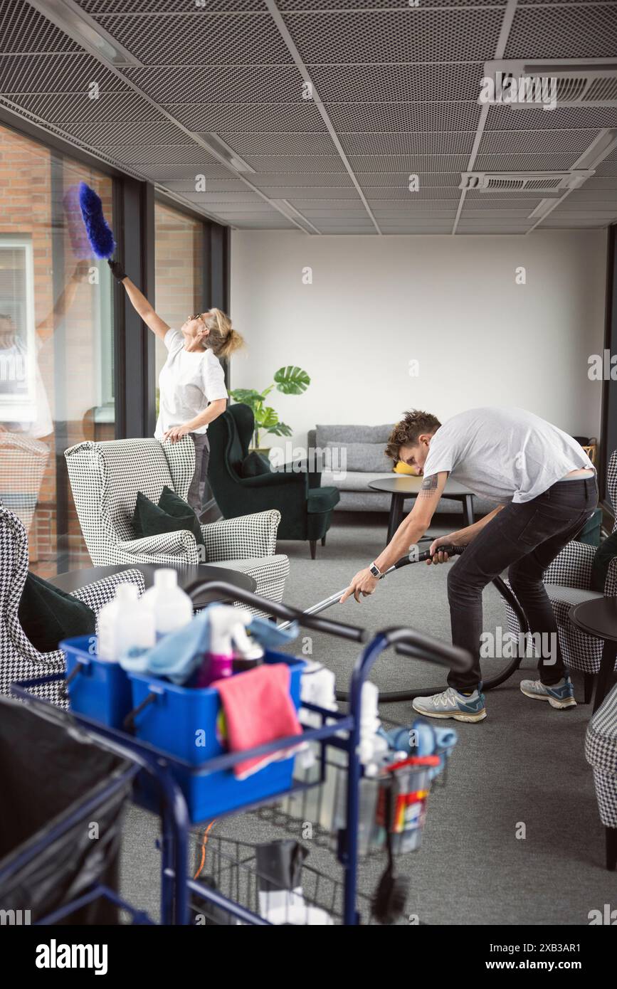 Female and male cleaners working together in lobby Stock Photo - Alamy