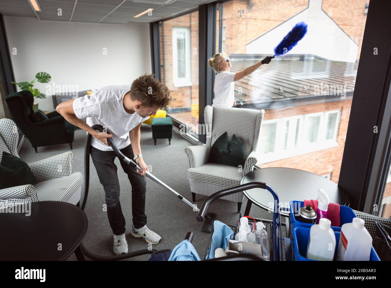 Female and male housekeeping staff cleaning lobby together Stock Photo ...