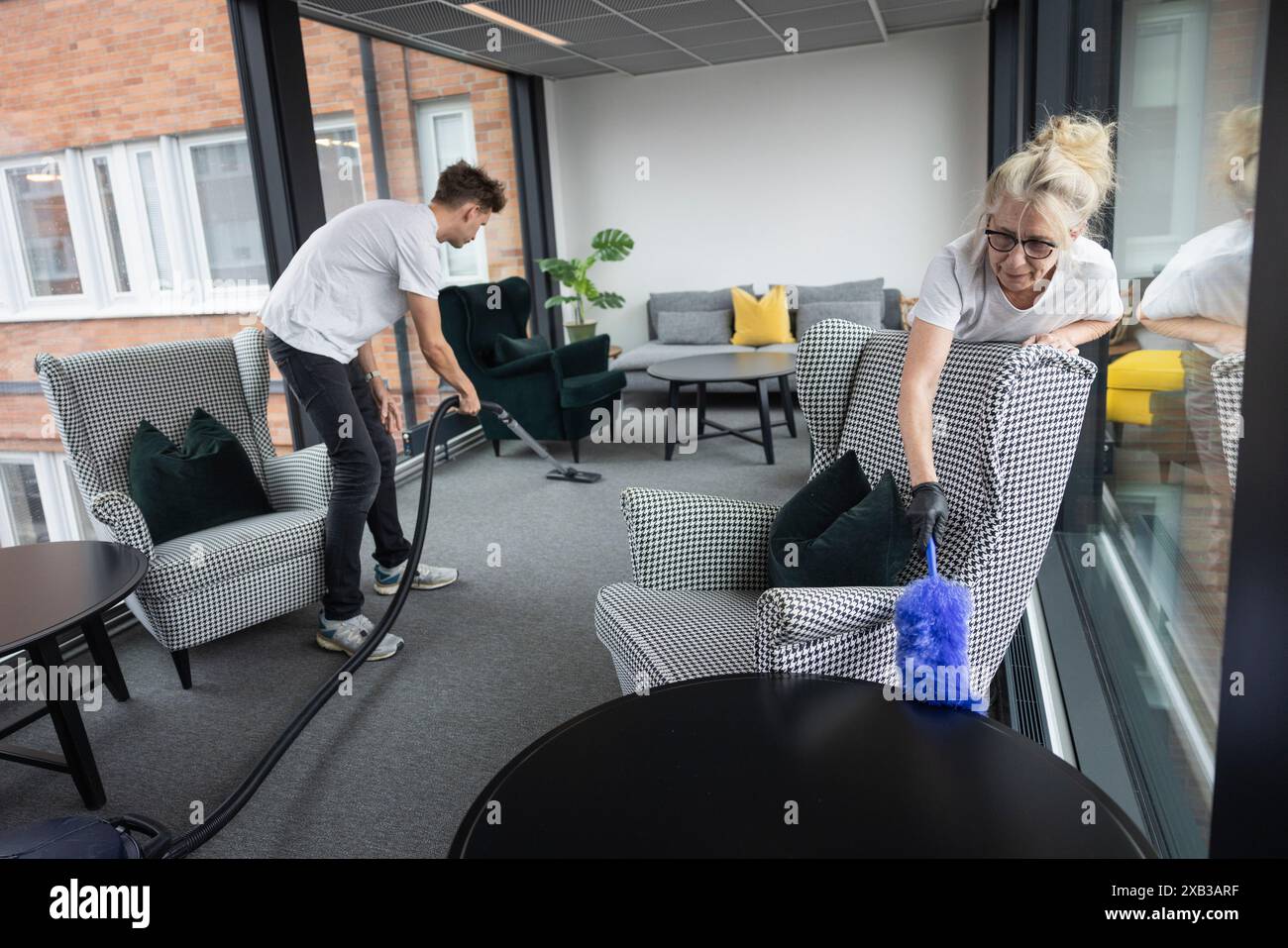 Housekeeping staff cleaning together in lobby Stock Photo - Alamy
