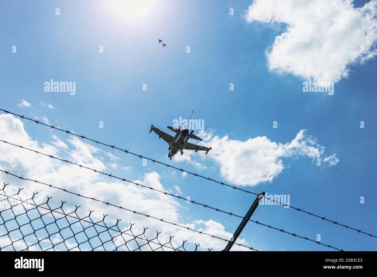 F-16 Fighting Falcon jet approaching landing behind barbed wire of the ...