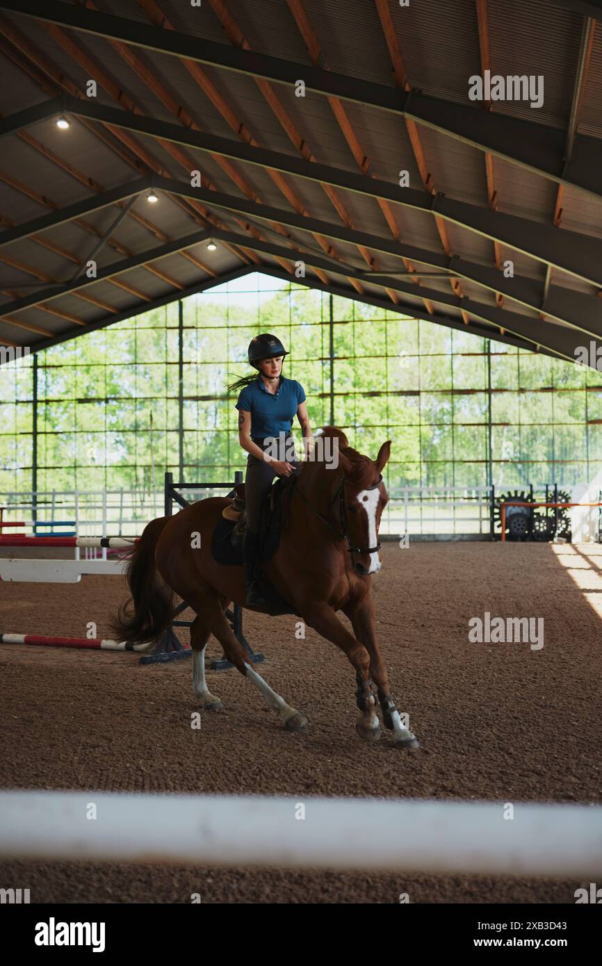Female jockey riding horse at paddock Stock Photo - Alamy