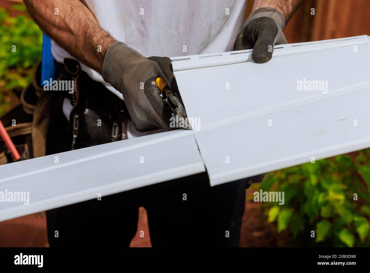 Facade of house is constructed by cutting vinyl siding panels to ...