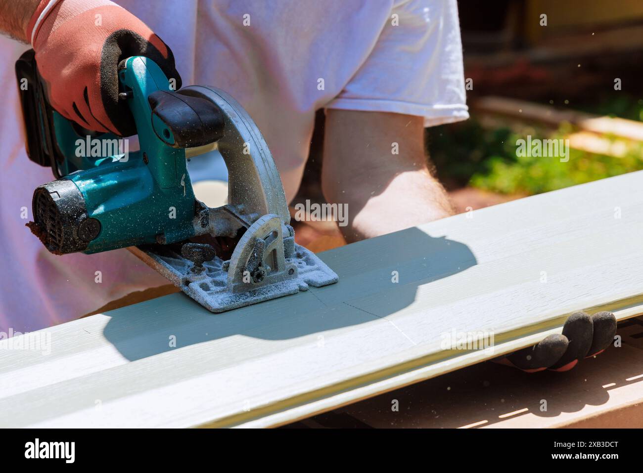 As part of construction process, craftsman cuts vinyl siding panels to ...