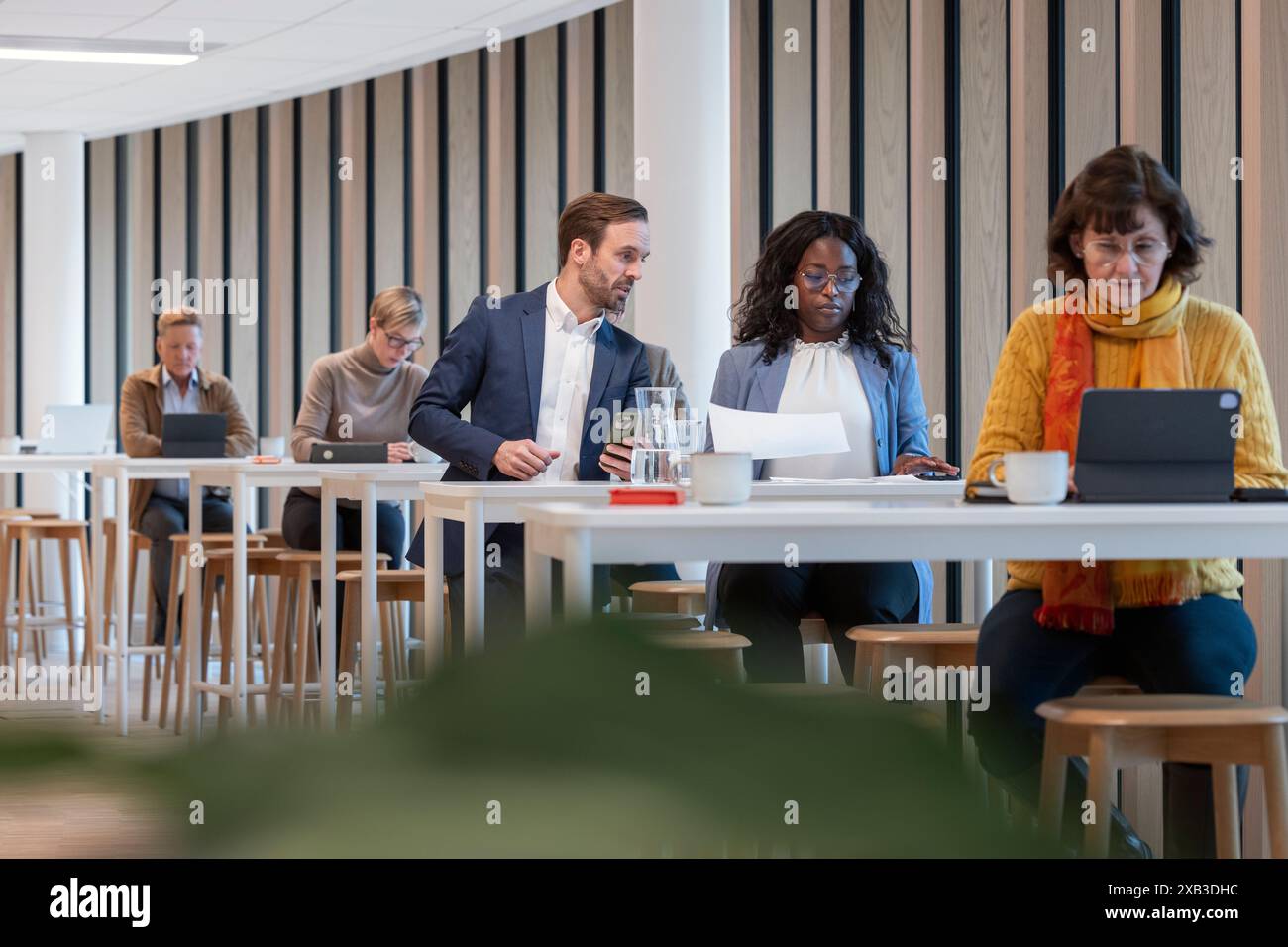 Multiracial colleagues working at table in office cafeteria Stock Photo ...