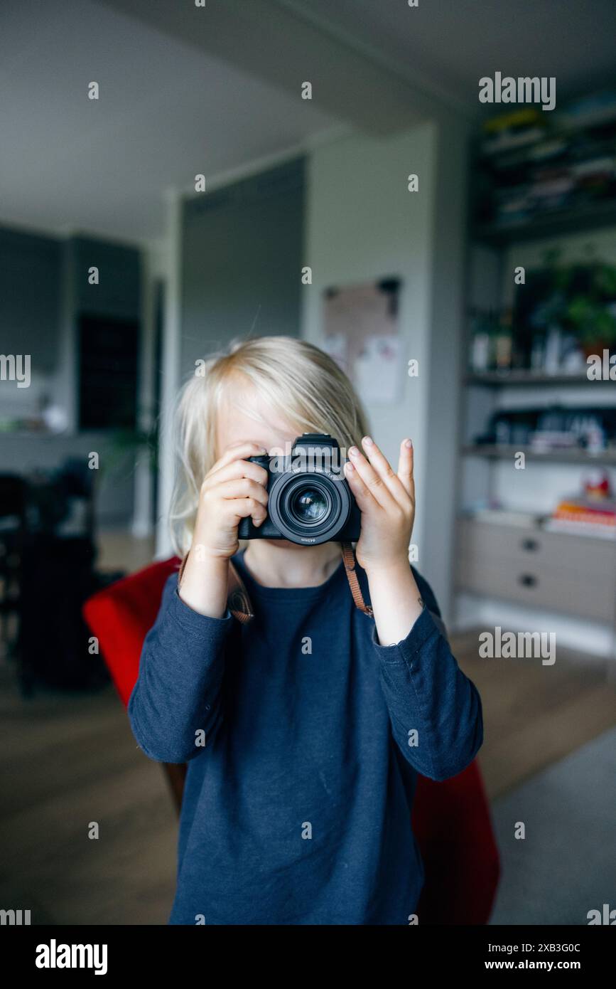 Boy photographing through camera at home Stock Photo - Alamy