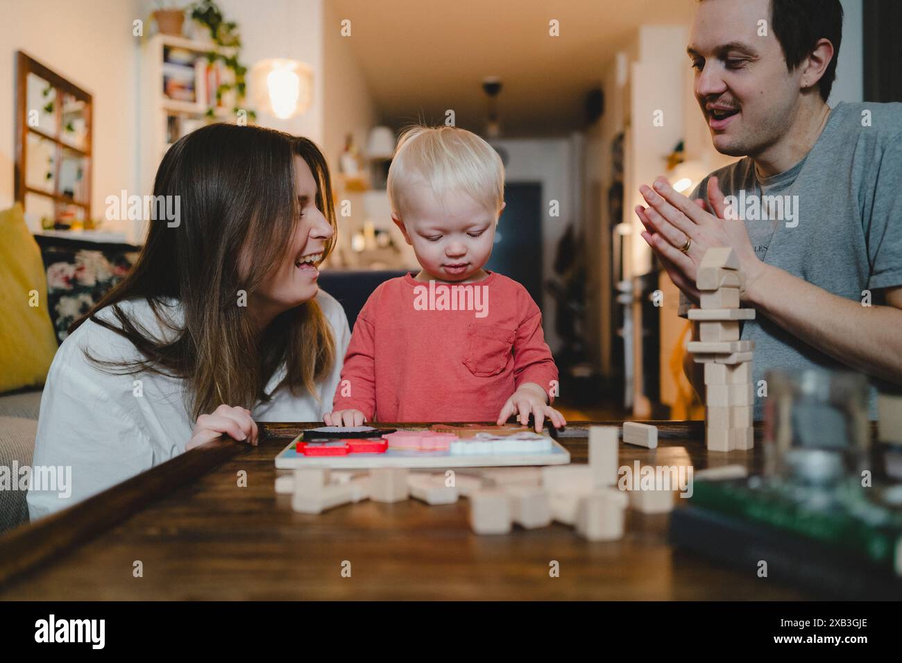 Cute boy stacking blocks with happy parents at home Stock Photo - Alamy