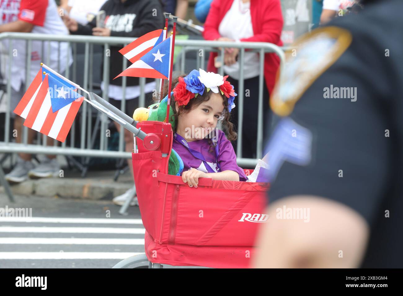 Girl is pulled in a wagon during the 67th National Puerto Rican Day ...
