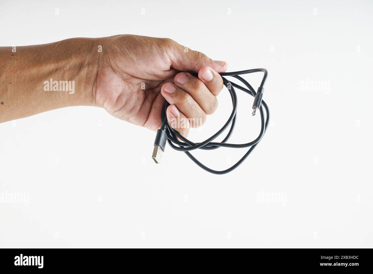 Hand holding wire charger on white background Stock Photo - Alamy