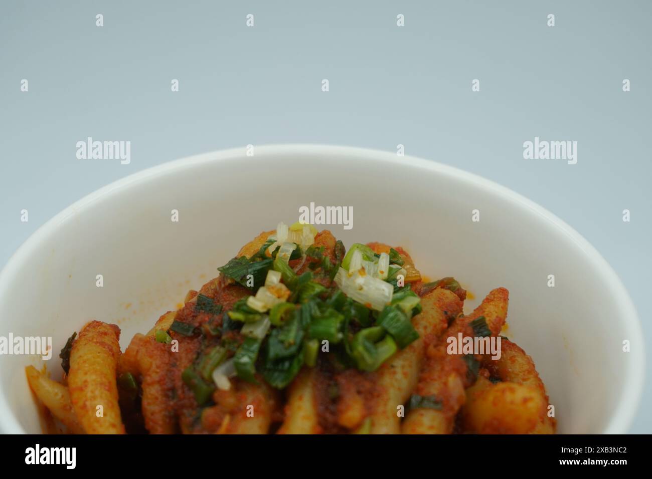 A bowl of spicy lou shu fan with spring onions on top and white ...