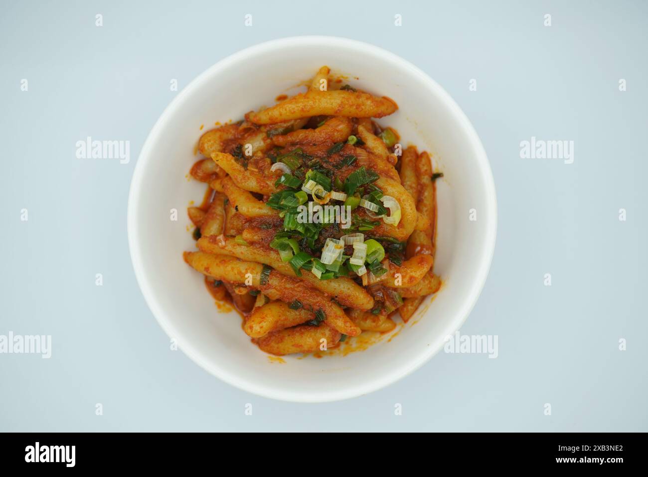 A bowl of spicy lou shu fan with spring onions on top and white ...