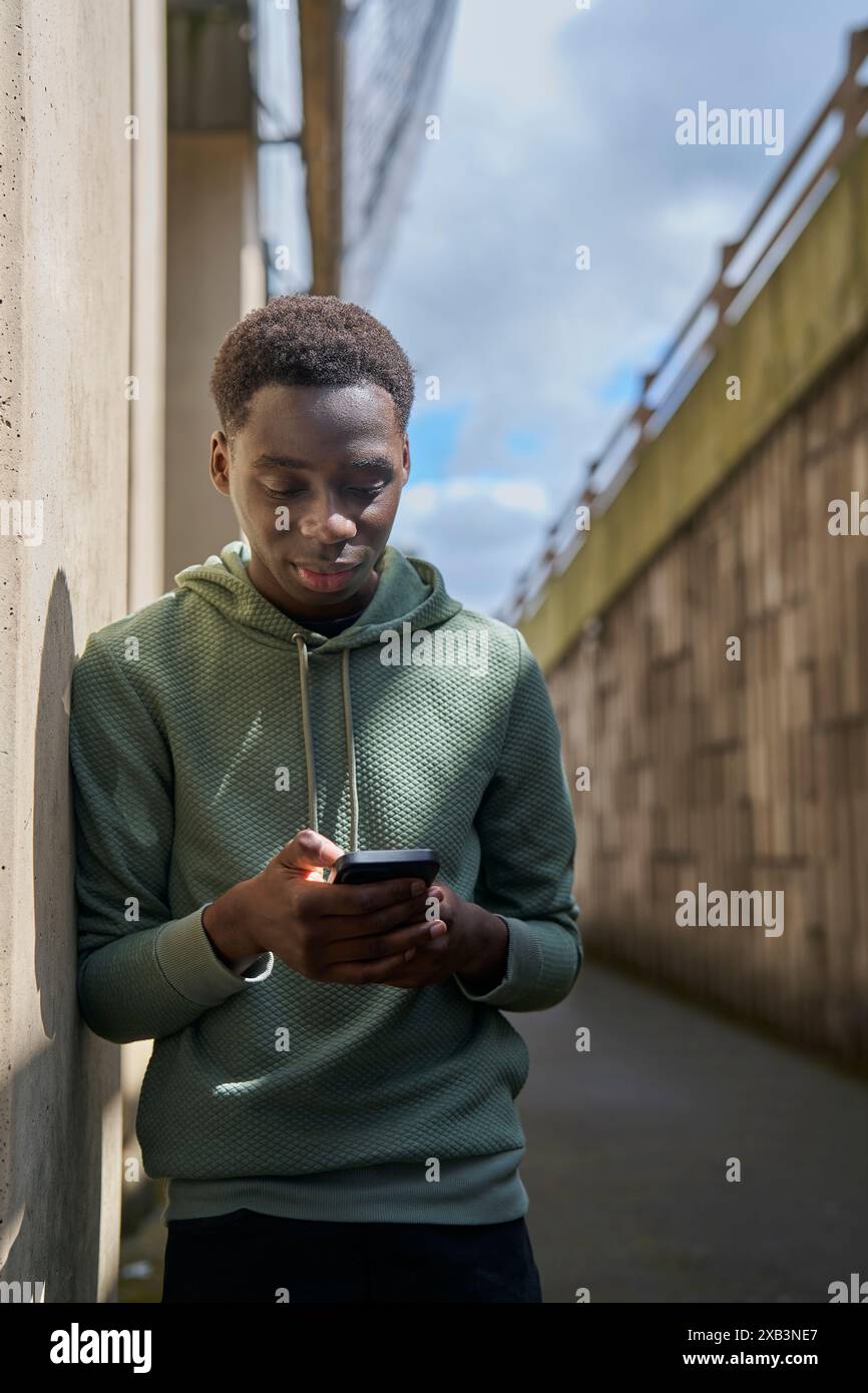 Teenage Boy Checking Social Media Or Text Messaging On Mobiile Phone ...
