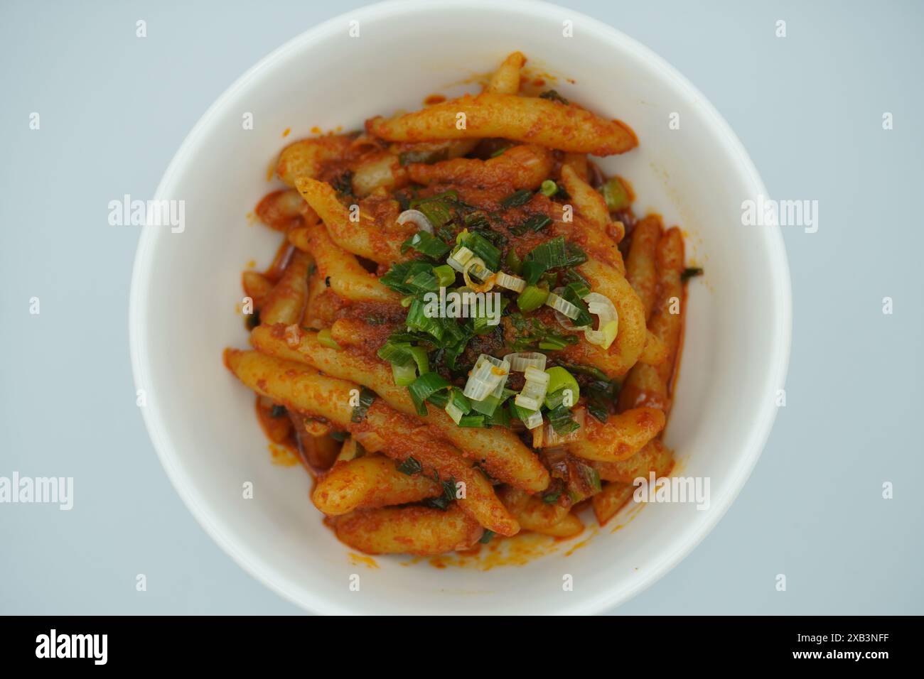 A bowl of spicy lou shu fan with spring onions on top and white ...