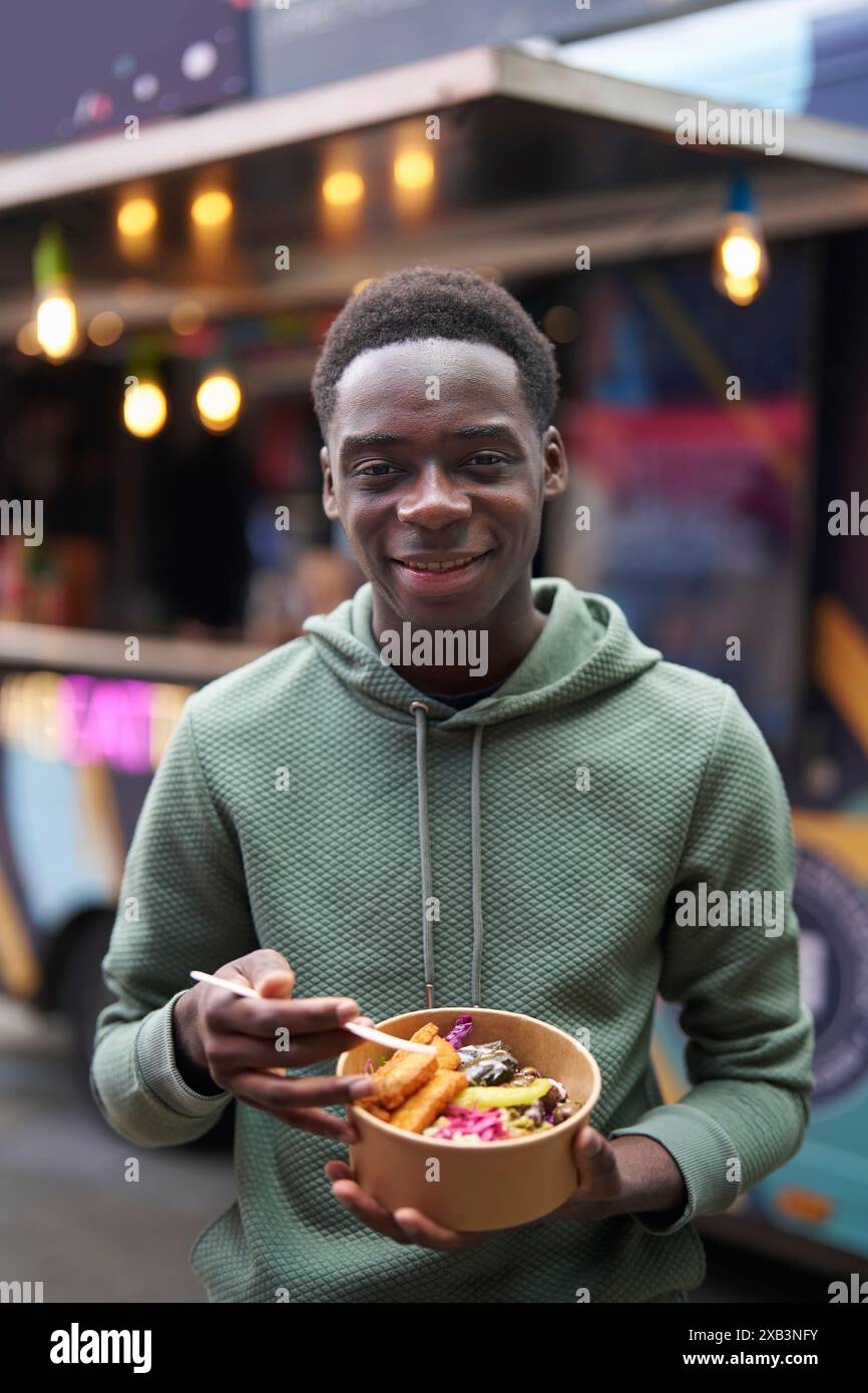 Portrait Of Teenage Boy Eating Vegan Mezze Bowl At Outdoor Street Food ...