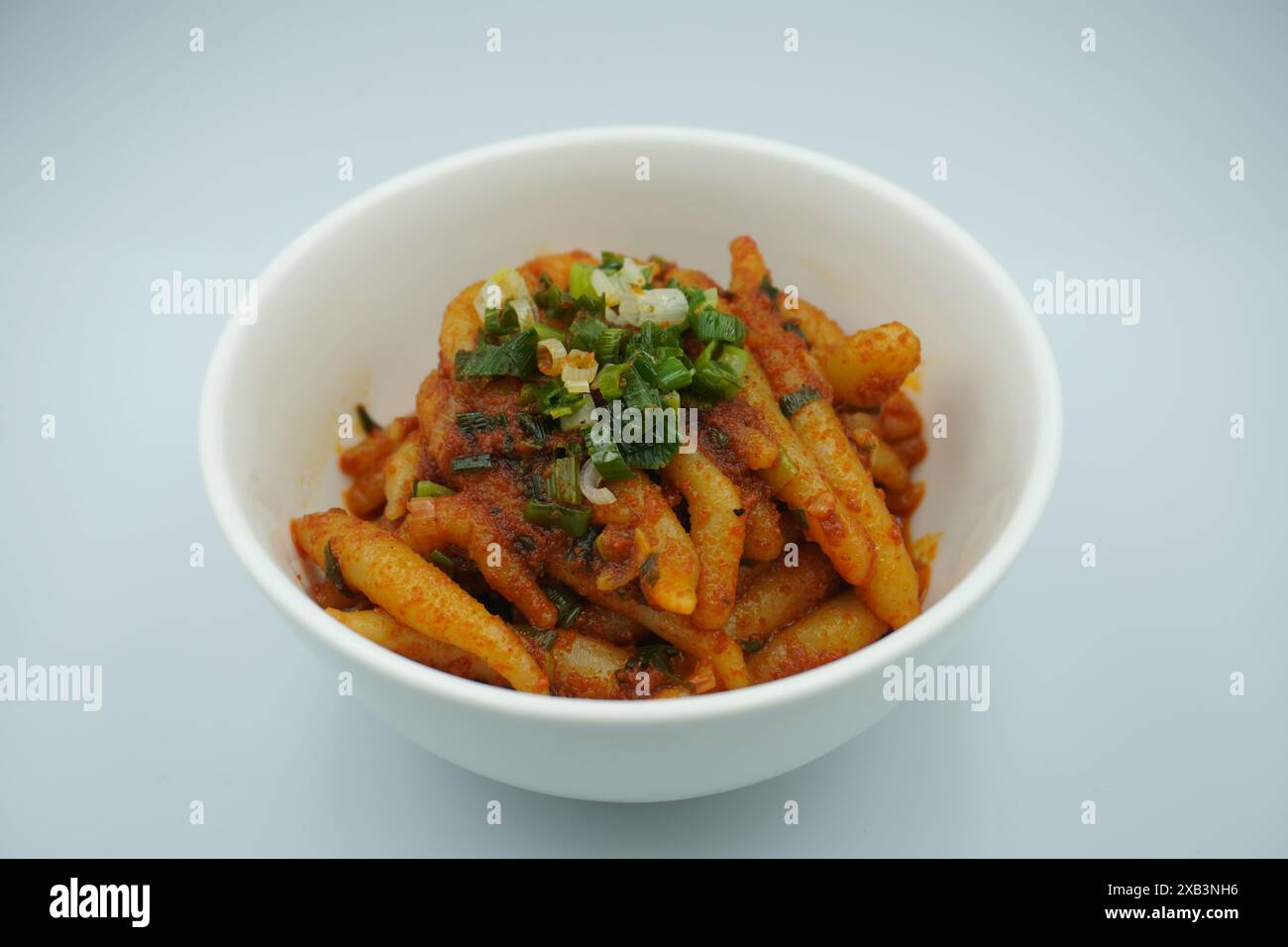 A bowl of spicy lou shu fan with spring onions on top and white ...