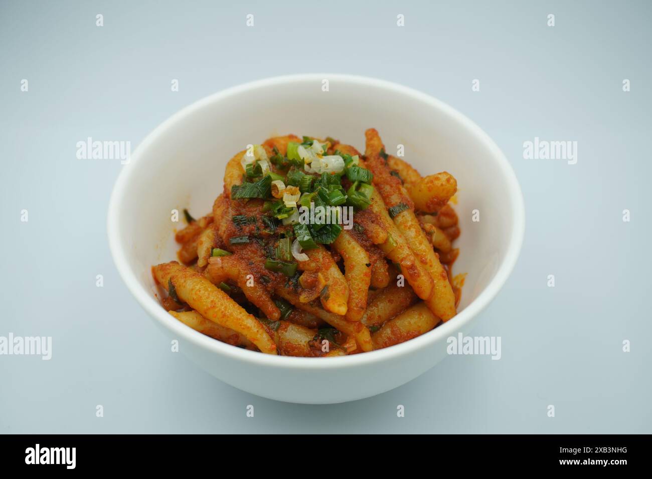 A bowl of spicy lou shu fan with spring onions on top and white ...