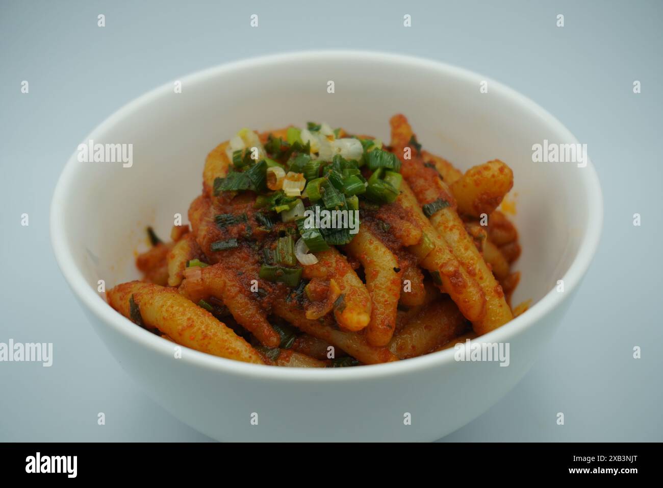 A bowl of spicy lou shu fan with spring onions on top and white ...