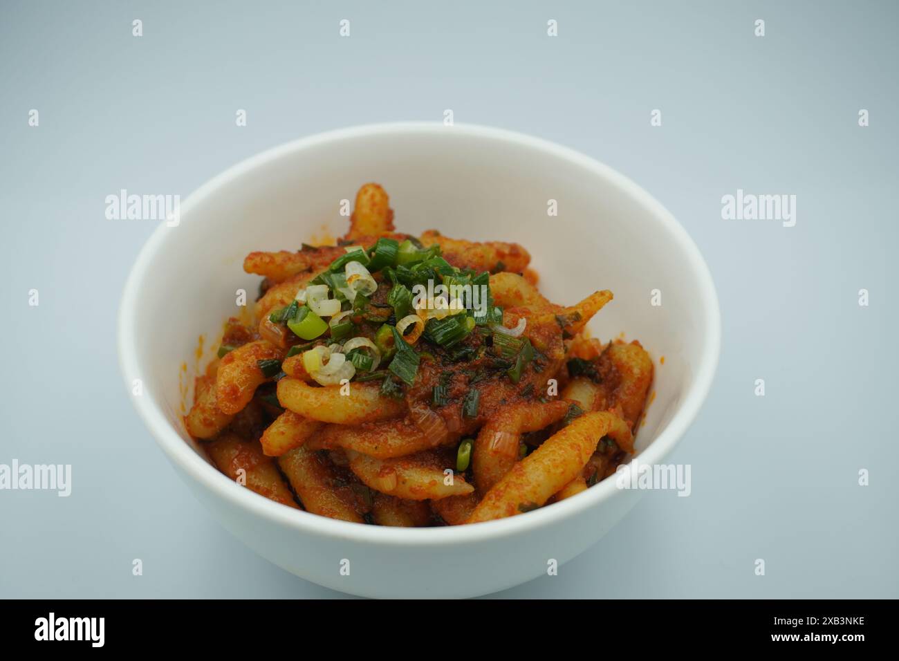 A bowl of spicy lou shu fan with spring onions on top and white ...