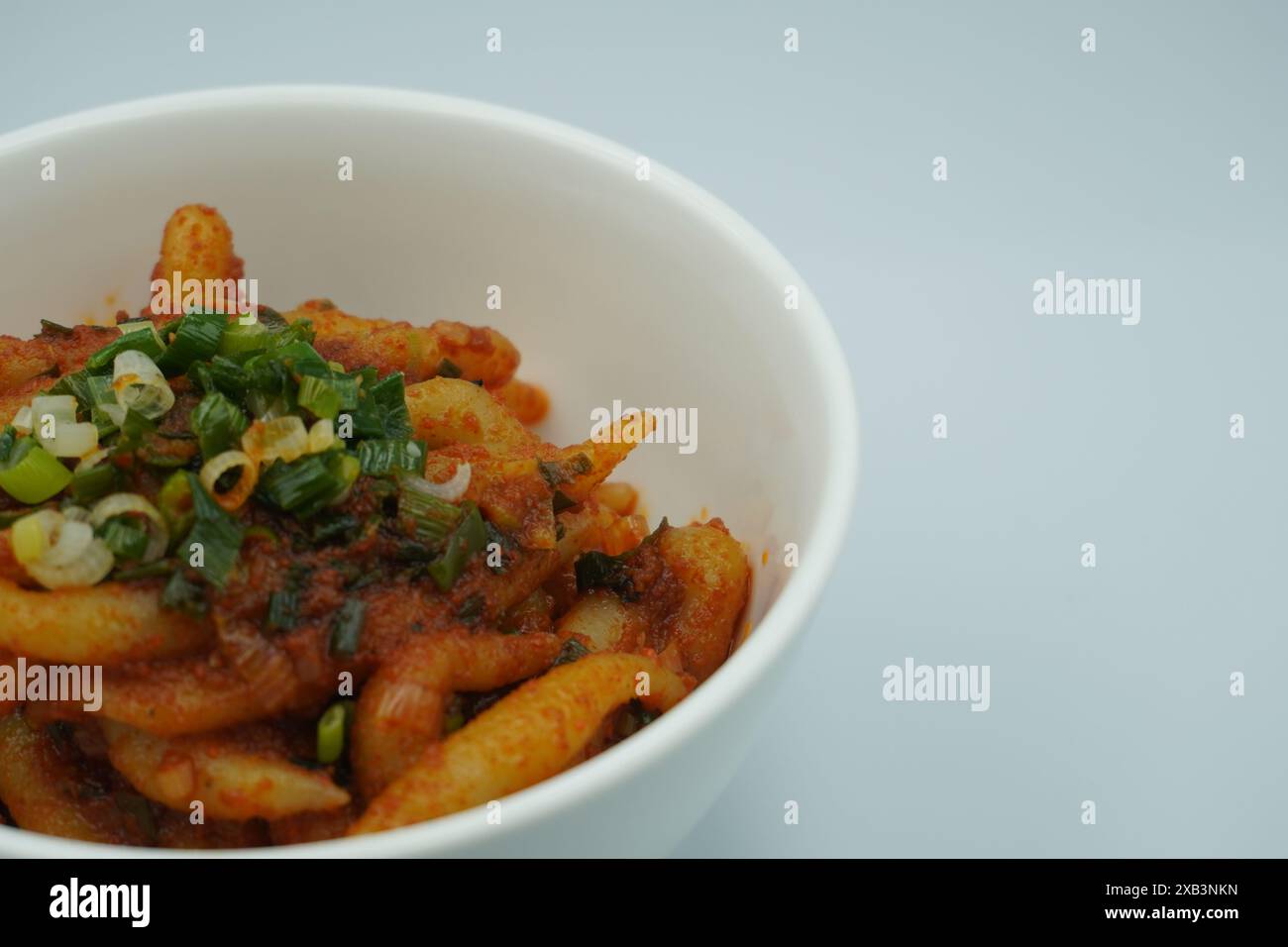 A bowl of spicy lou shu fan with spring onions on top and white ...