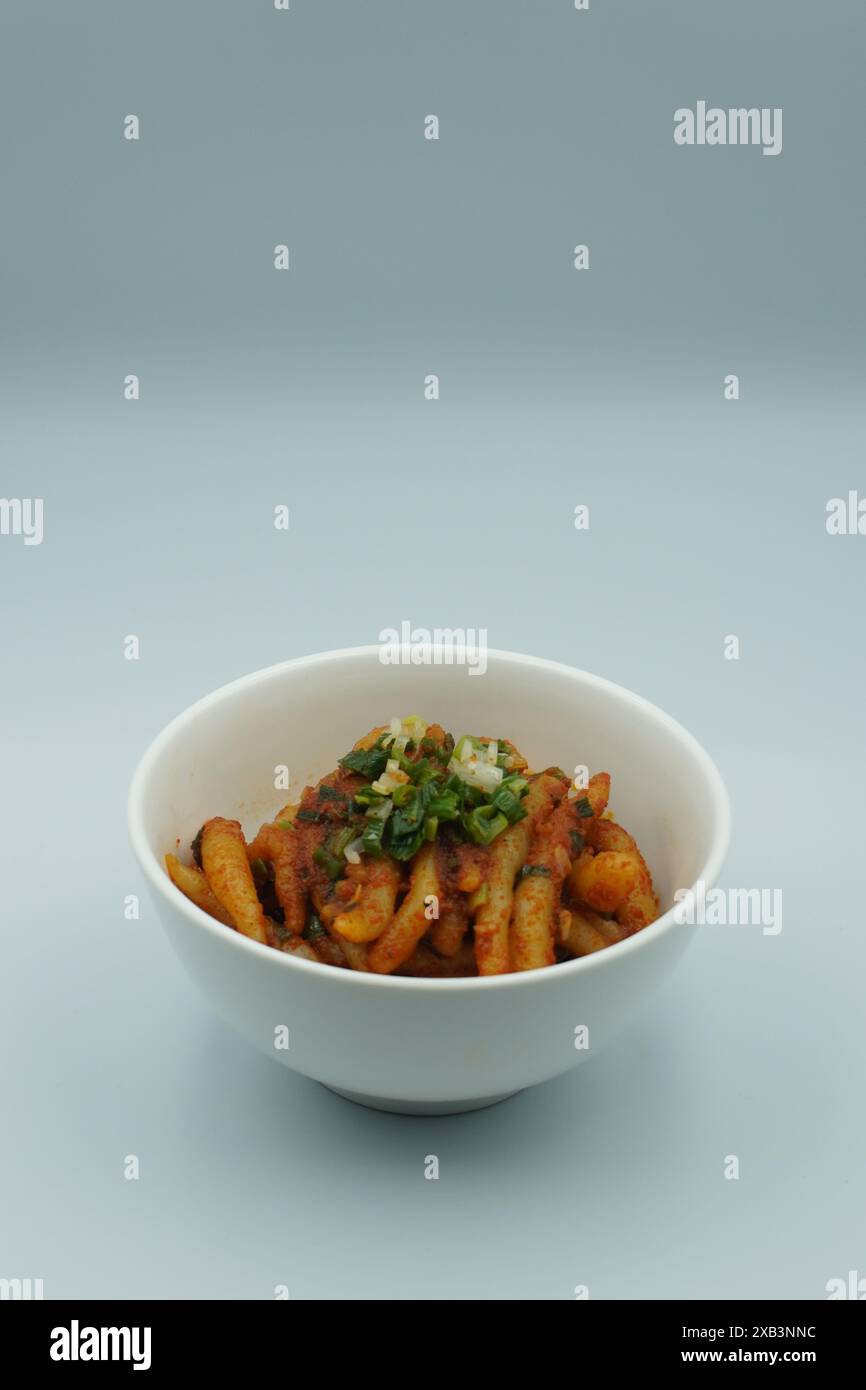 A bowl of spicy lou shu fan with spring onions on top and white ...