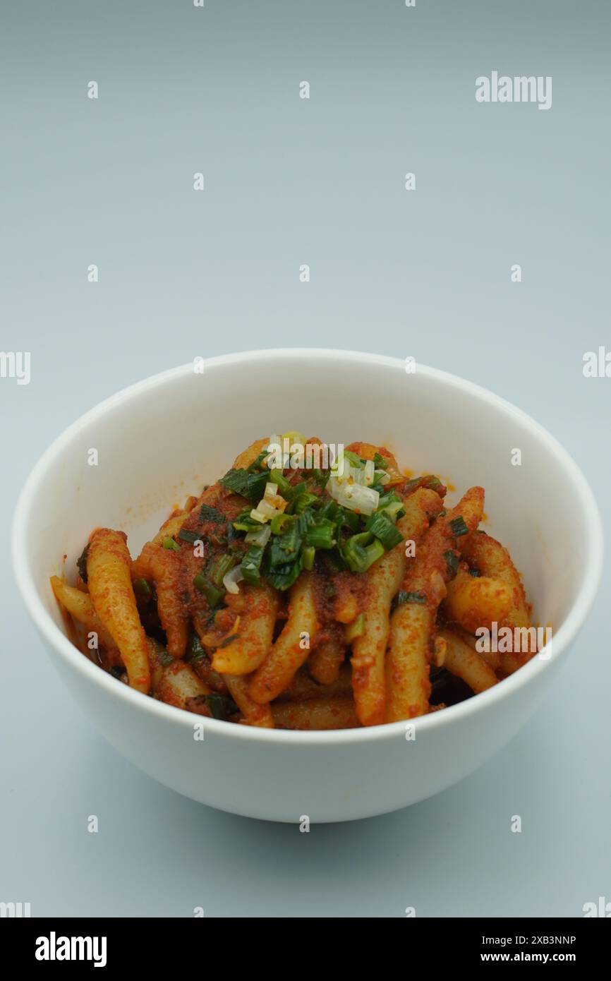 A bowl of spicy lou shu fan with spring onions on top and white ...