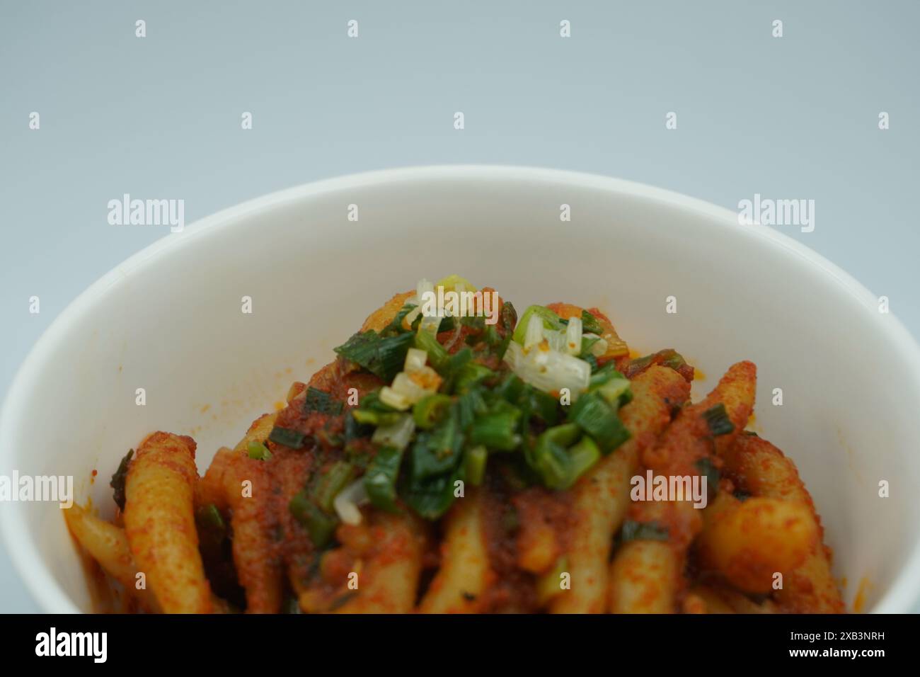 A bowl of spicy lou shu fan with spring onions on top and white ...