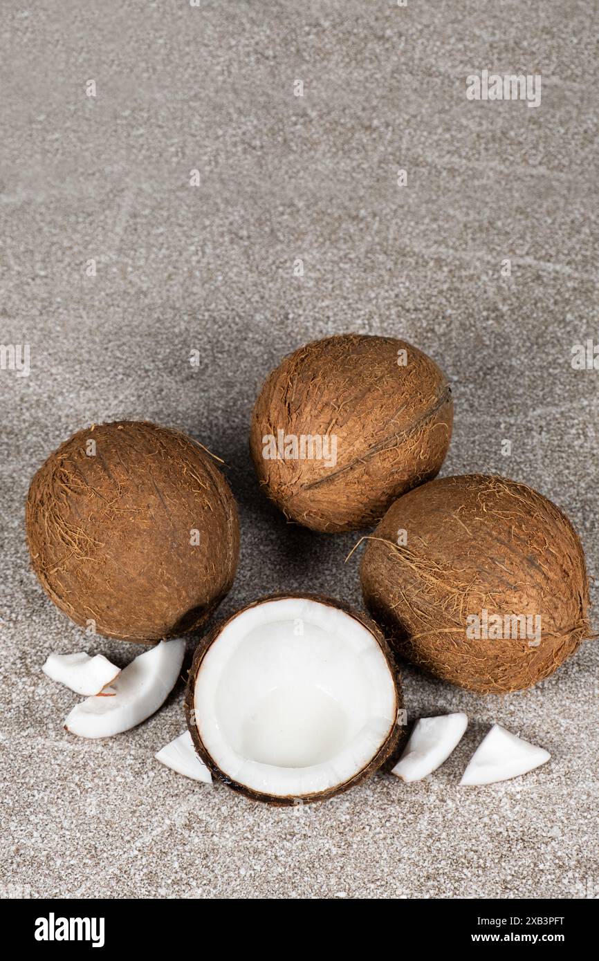 Whole coconuts and half a coconut on a blue and gray background close ...