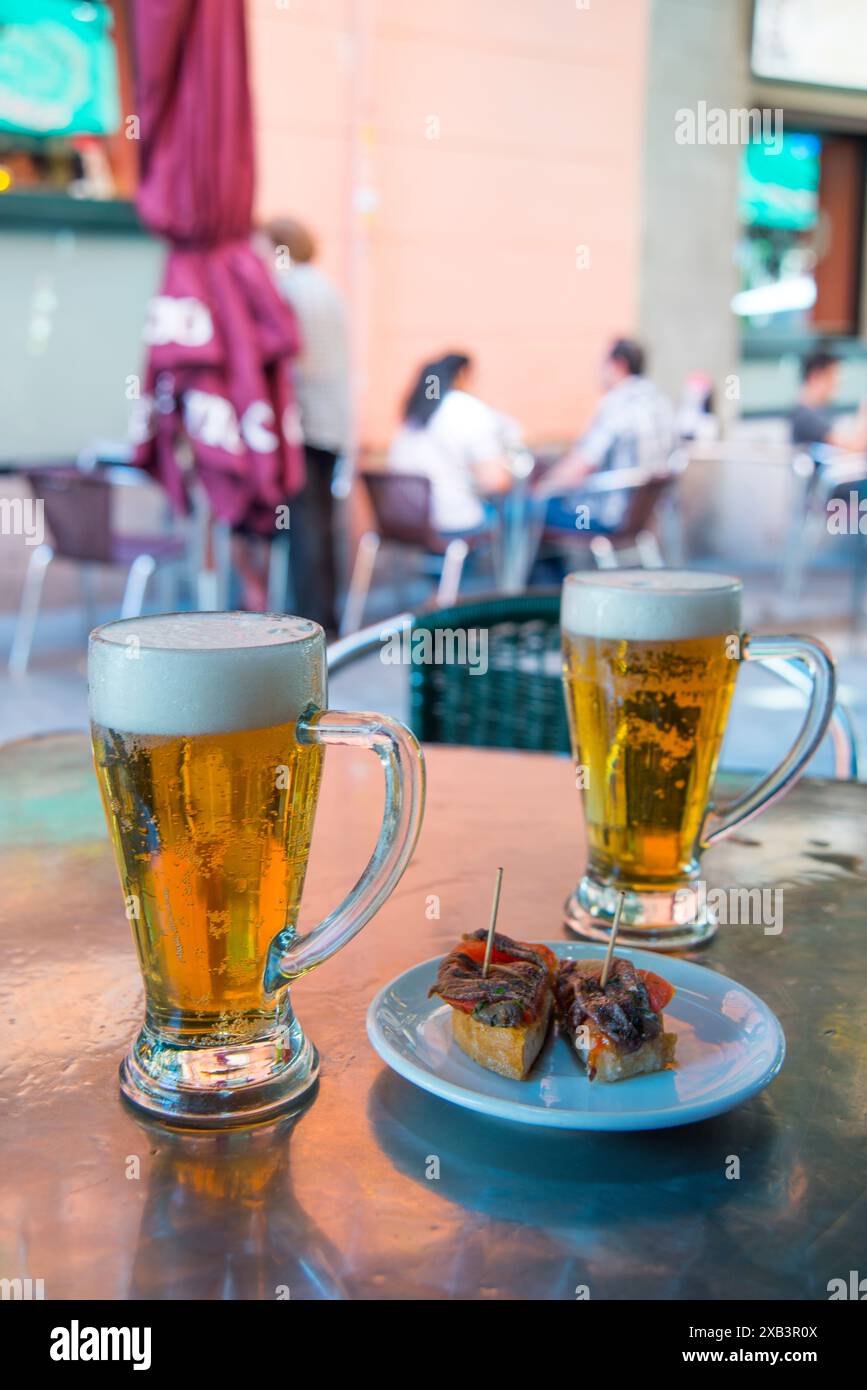 Spanish aperitif: two glasses of beer with tapa on a terrace. Madrid ...