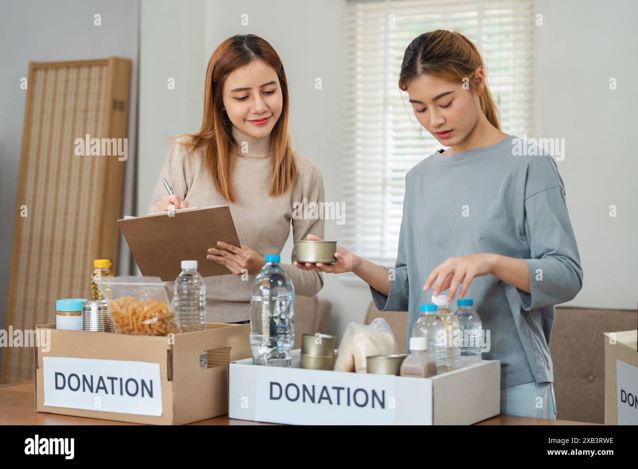 Women Organizing Food Donations in Boxes for Charity - volunteer and ...