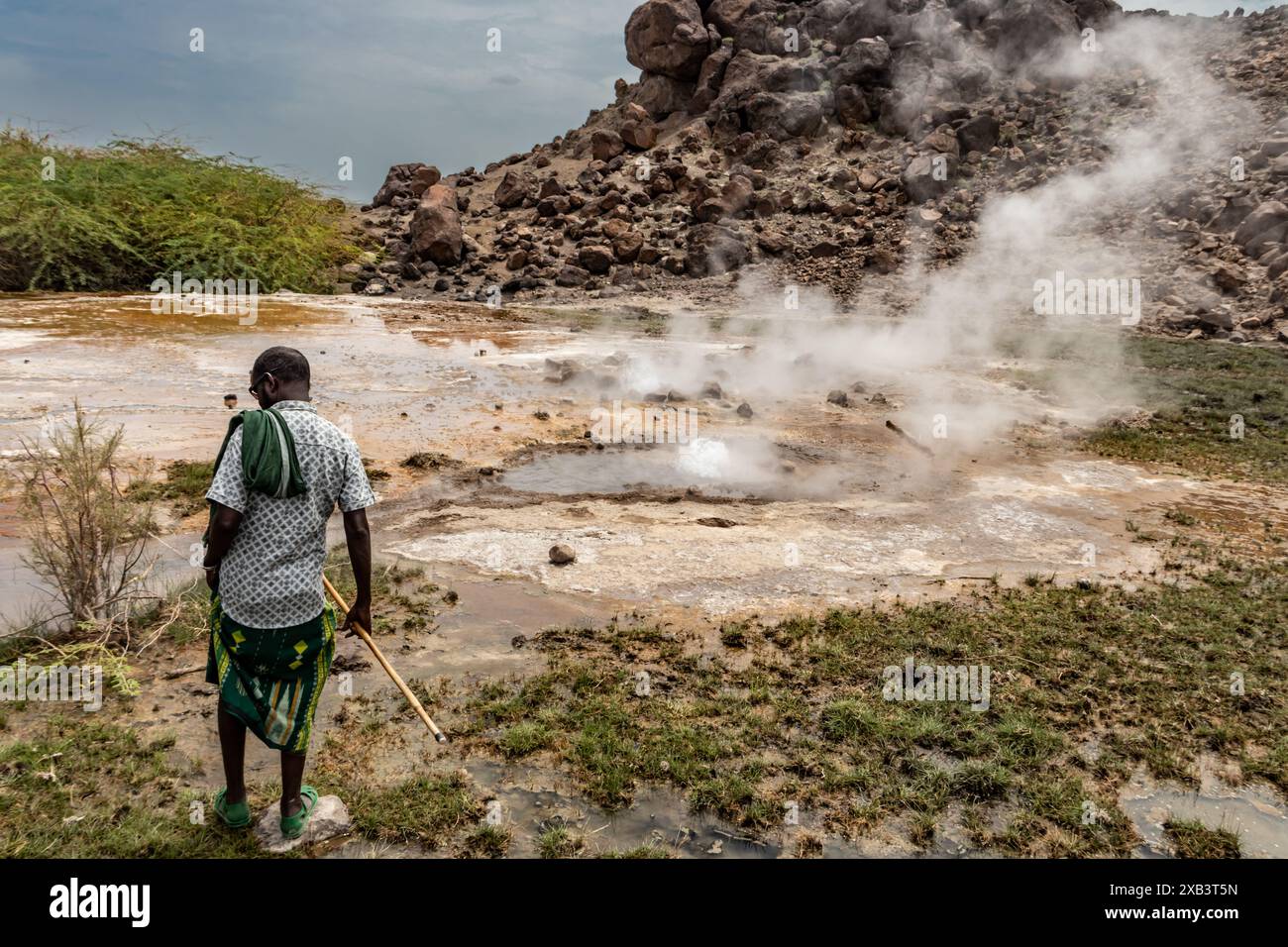 Local tour guide traditionally dressed showing hot geothermal volcanic ...