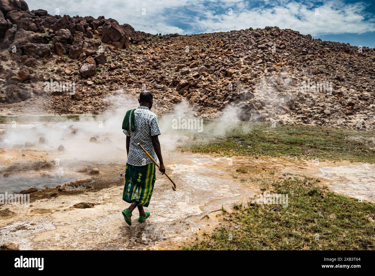 Local tour guide traditionally dressed showing hot geothermal volcanic ...