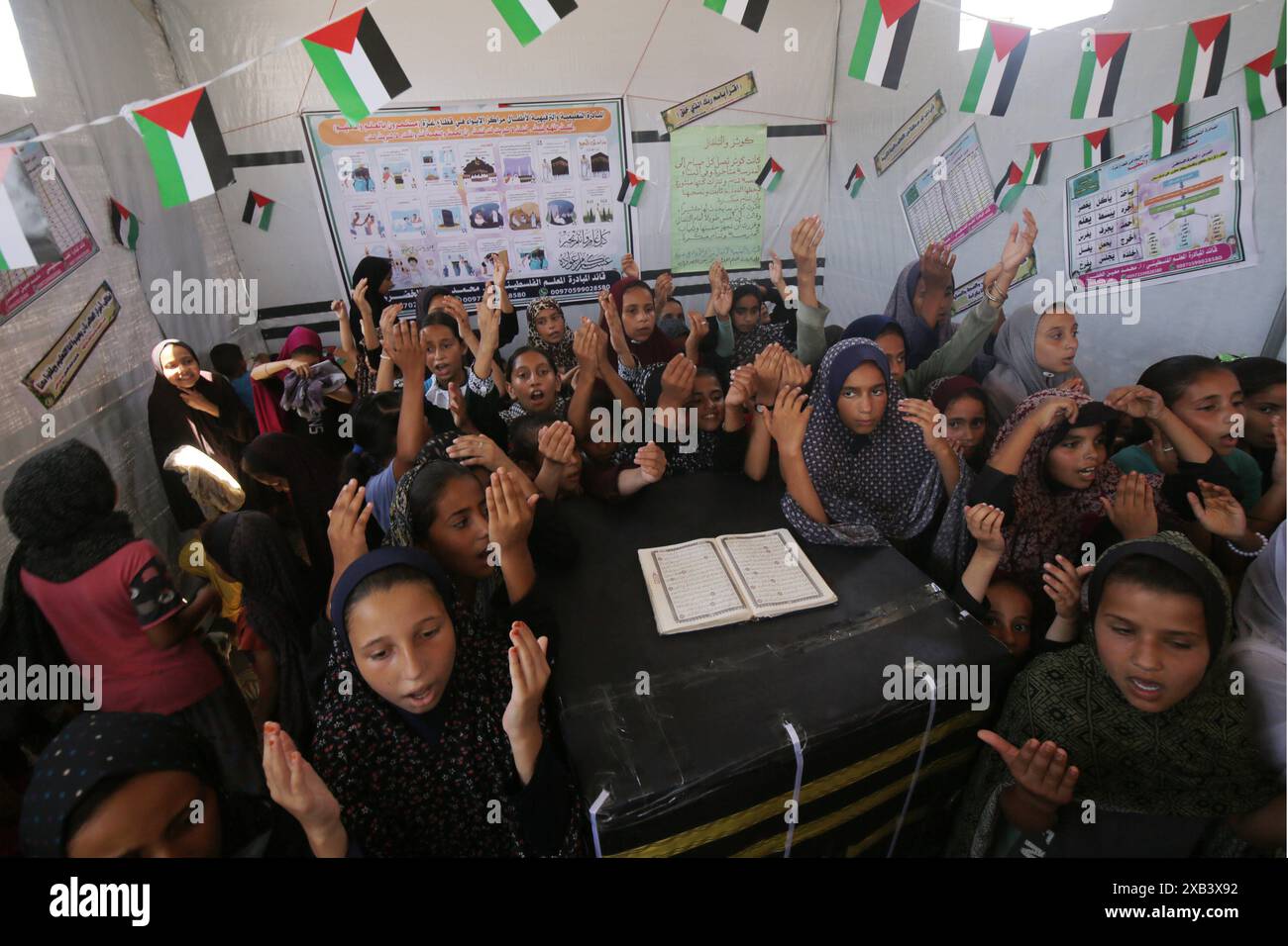 Displaced Palestinian children gather around a makeshift cube ...