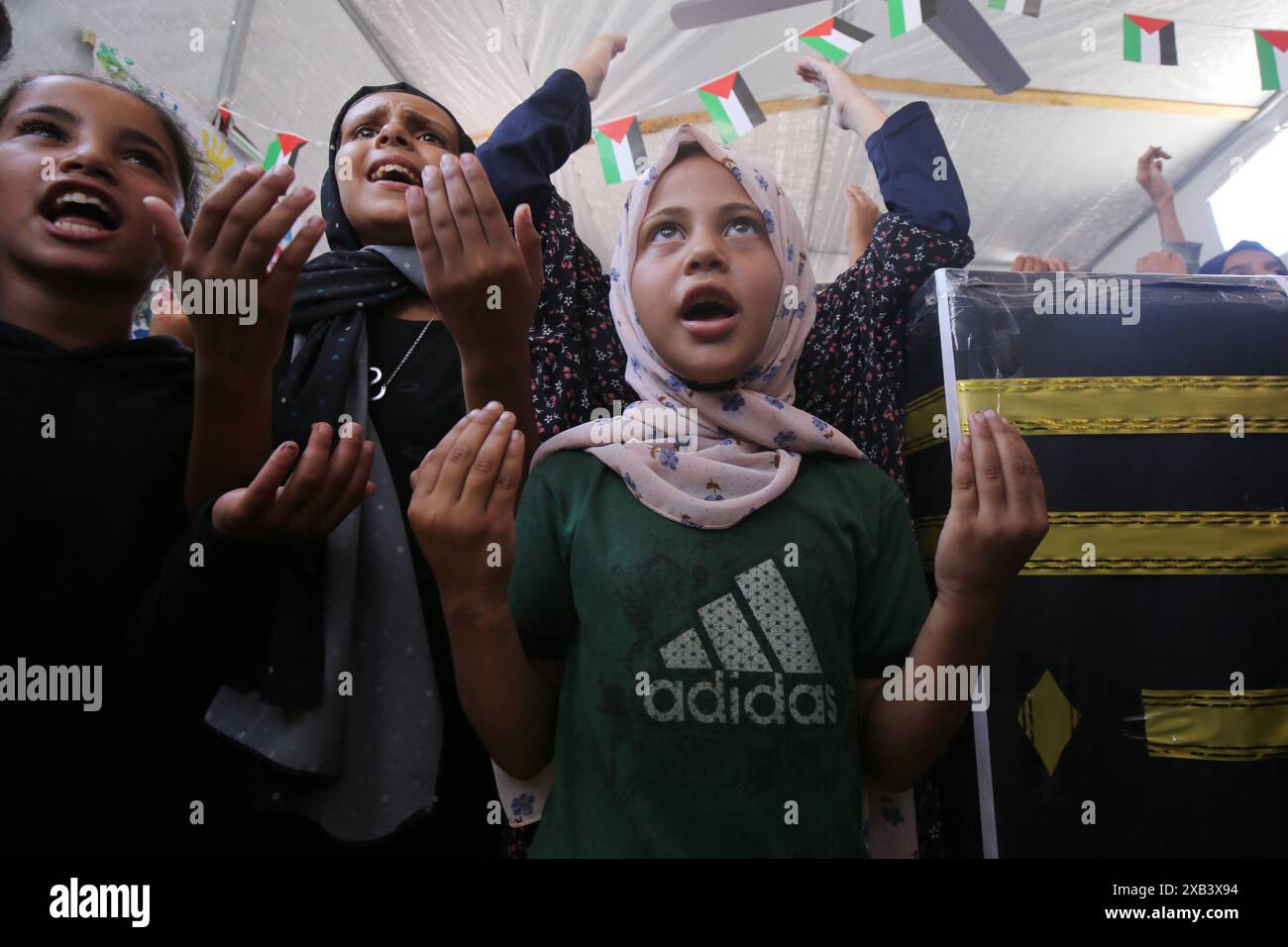 Displaced Palestinian children gather around a makeshift cube ...