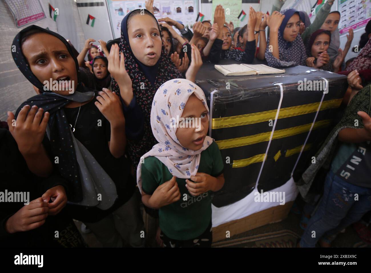 Displaced Palestinian children gather around a makeshift cube ...