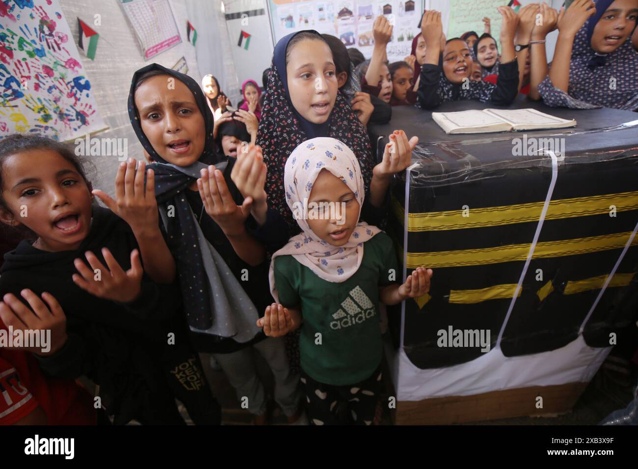 Displaced Palestinian children gather around a makeshift cube ...