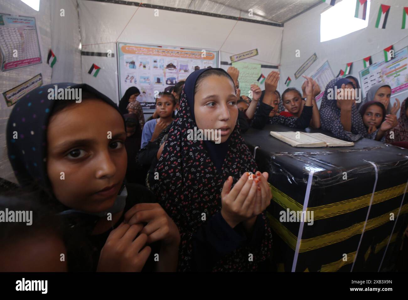 Displaced Palestinian children gather around a makeshift cube ...