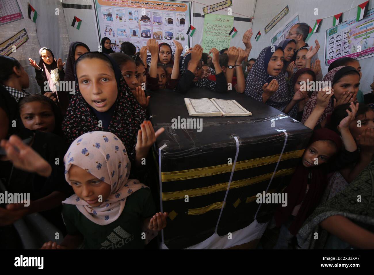 Displaced Palestinian children gather around a makeshift cube ...