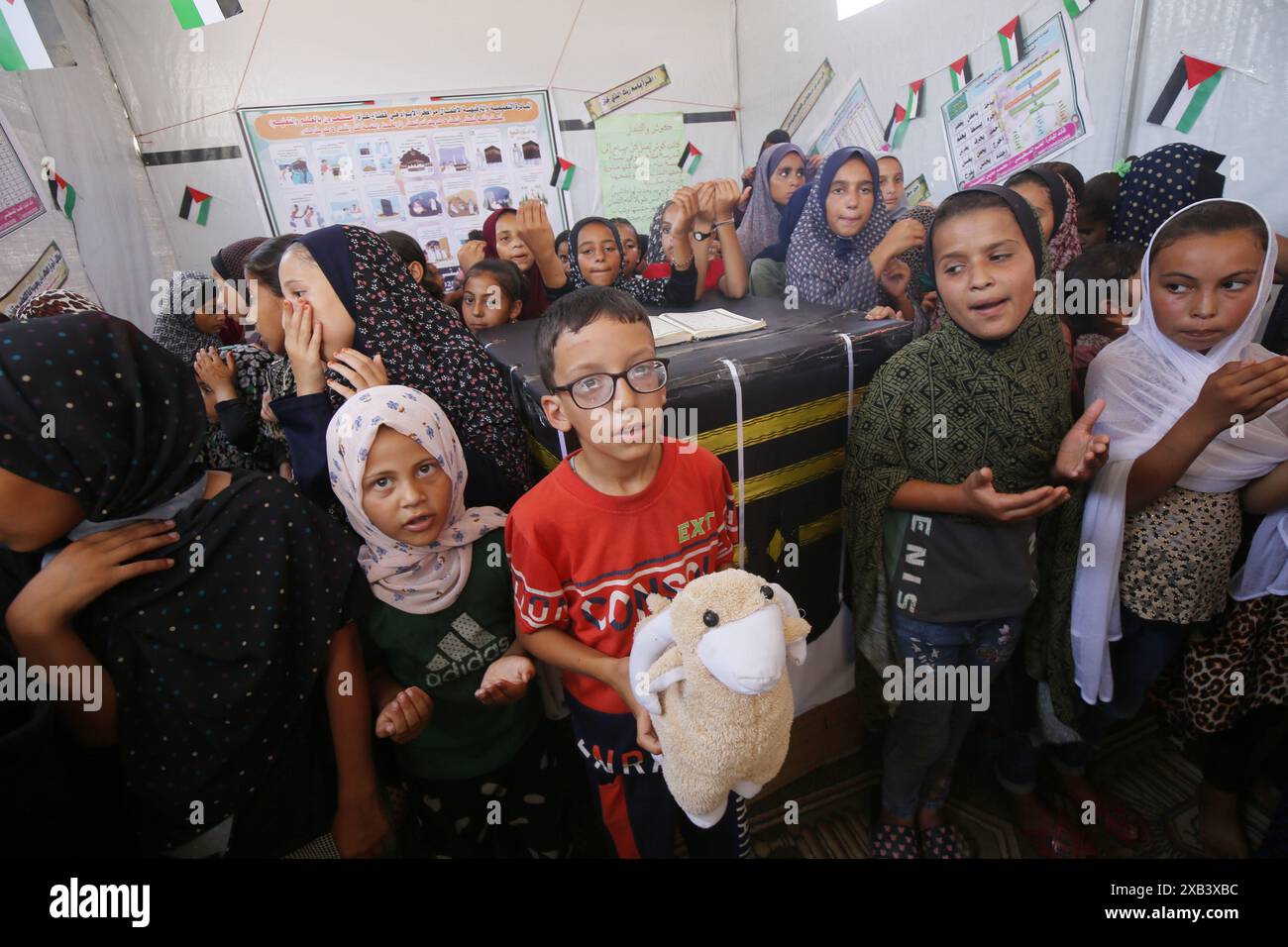 Displaced Palestinian children gather around a makeshift cube ...