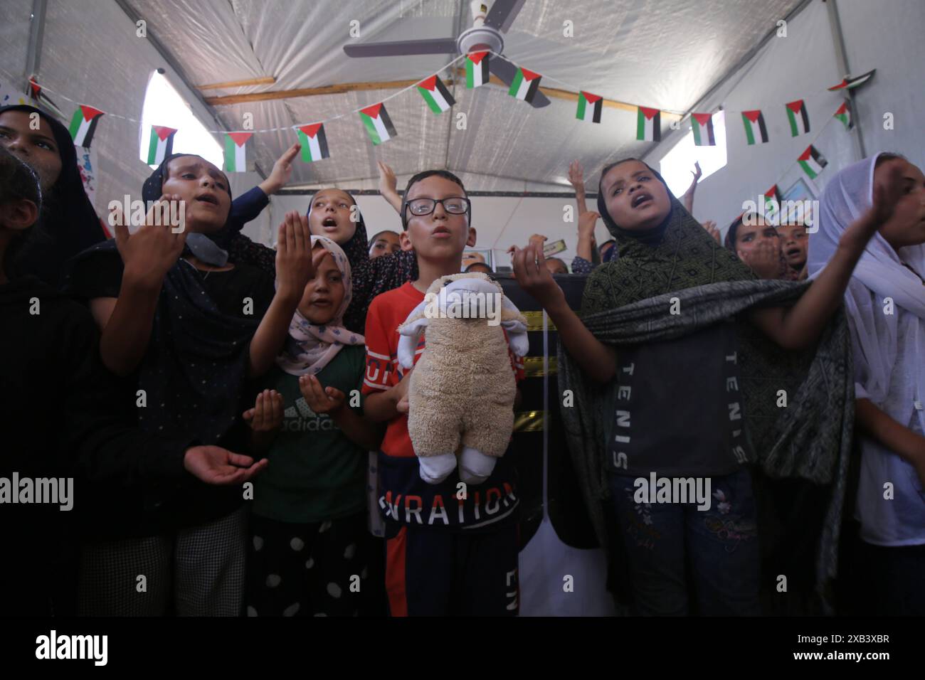Displaced Palestinian children gather around a makeshift cube ...
