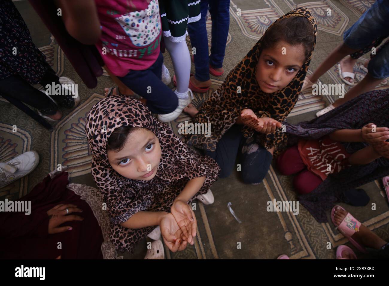 Displaced Palestinian children gather around a makeshift cube ...