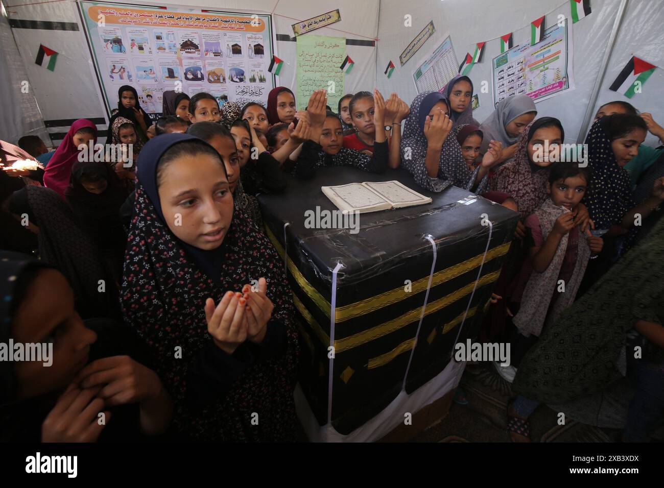 Displaced Palestinian children gather around a makeshift cube ...